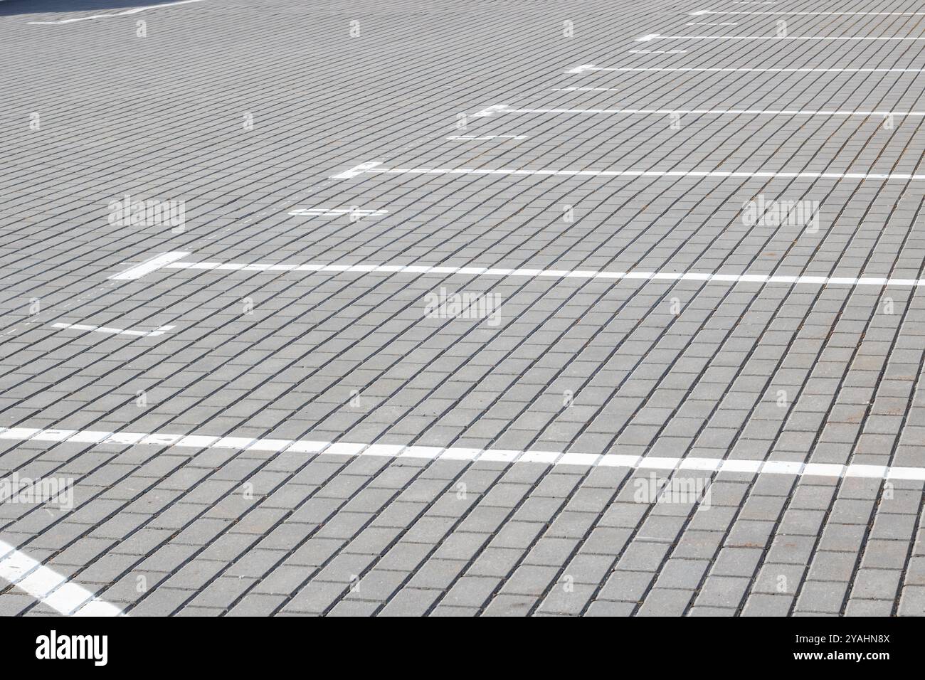 A spacious brick parking lot that features prominent white lines ...