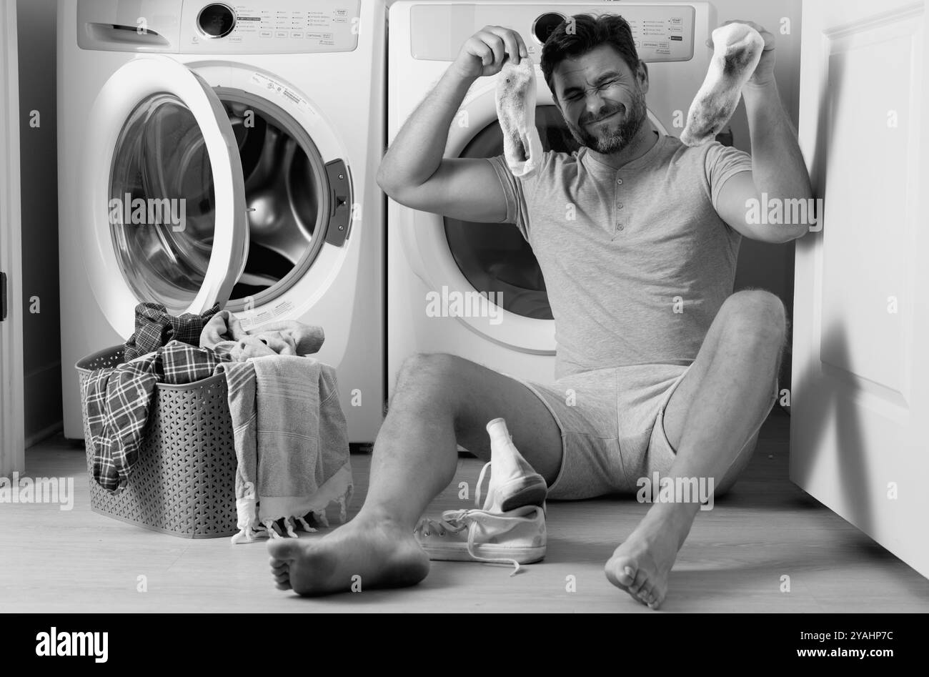 Man with clothes near washing machine. Laundry cleaning. Housework, homework, male housekeeper ...