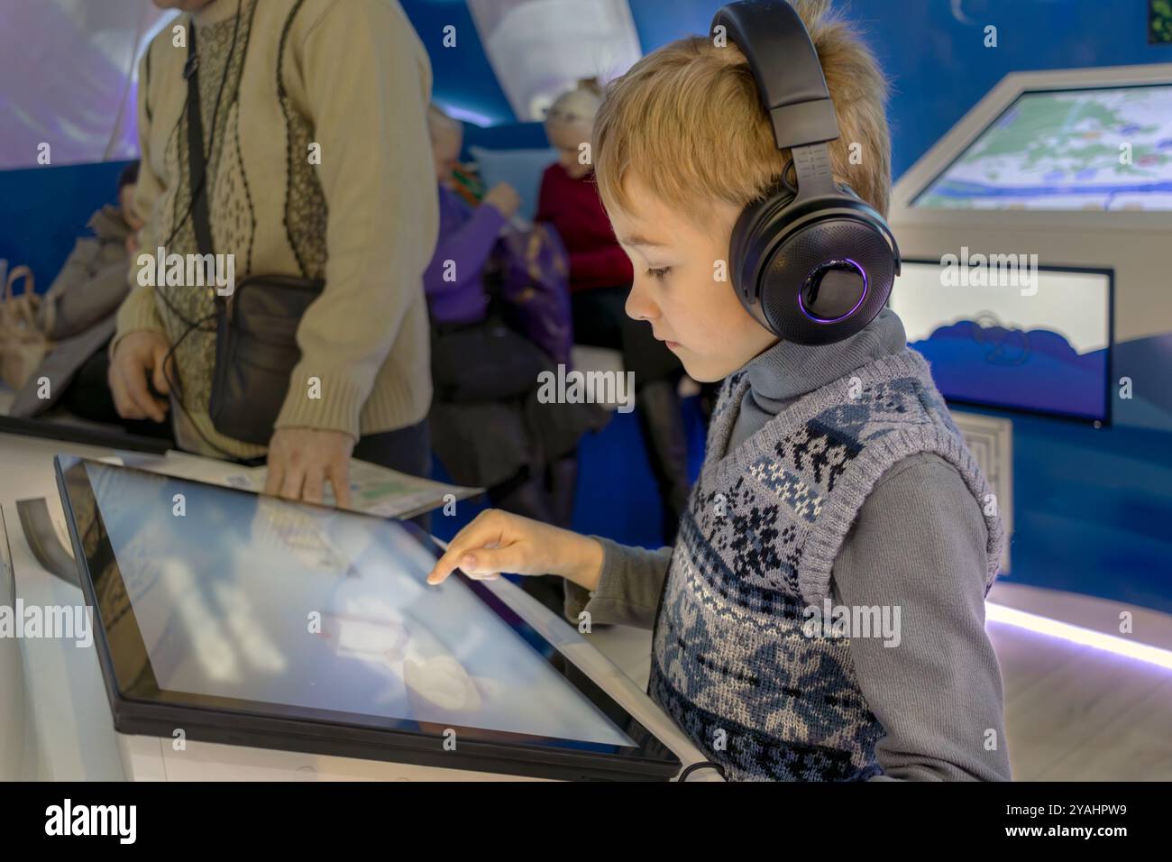 Immersion in world of technology: child wearing headphones in front of ...