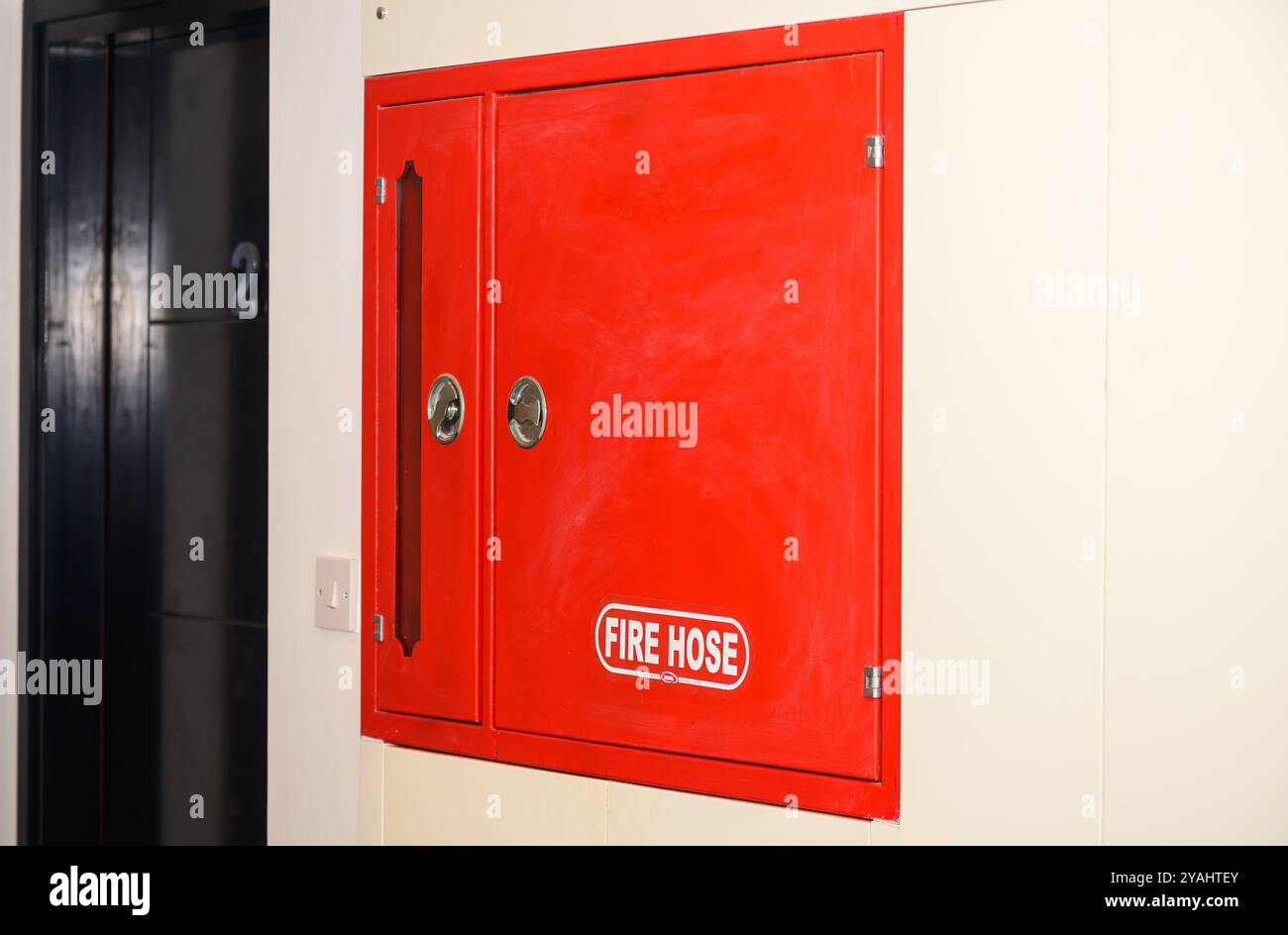 Red fire shield with fire extinguisher in a business center Stock Photo ...