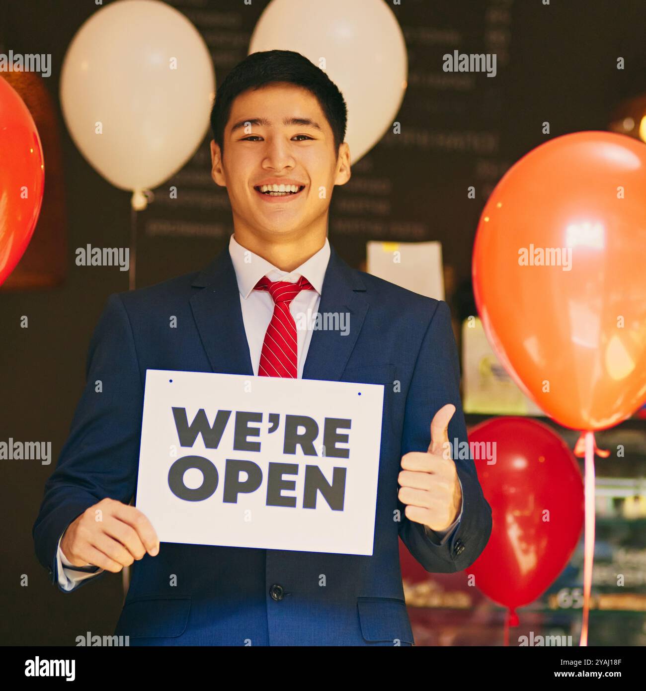 Happy, smiling man in formal wear with thumbs-up, standing with we are ...