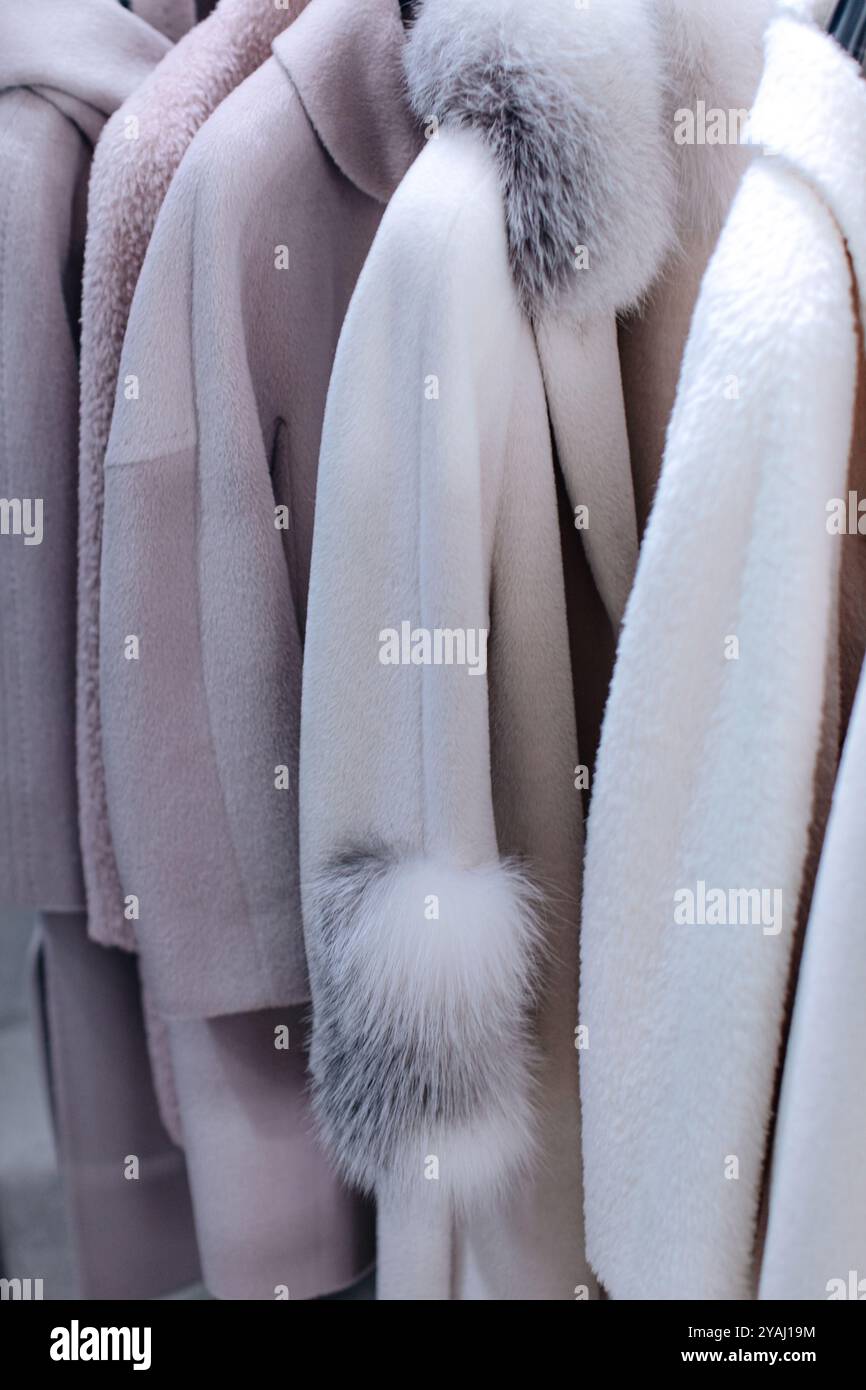 White and grey fur coats for women hanging in a row in a winter ...