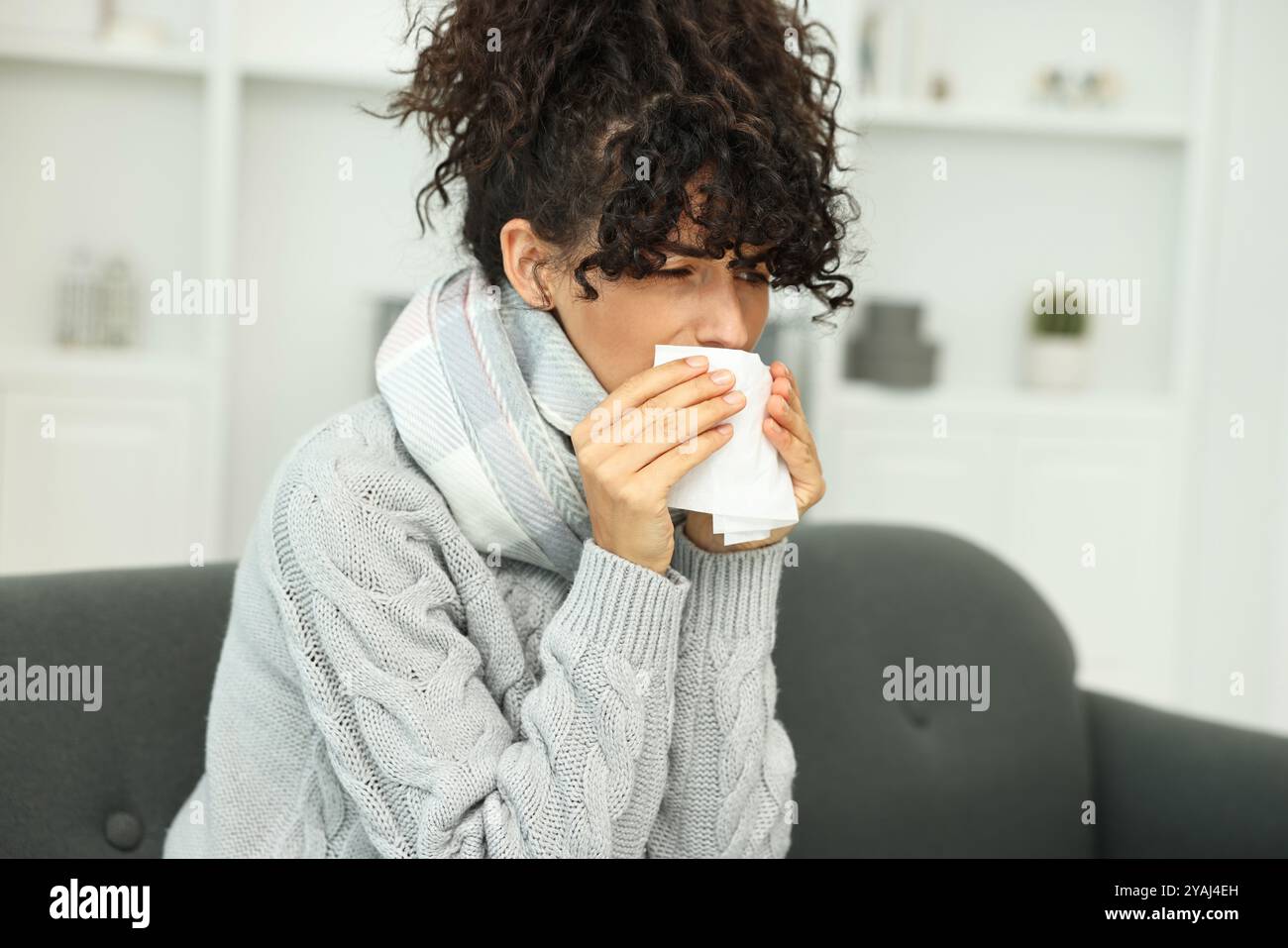 Cold symptom. Young woman with tissue at home Stock Photo - Alamy