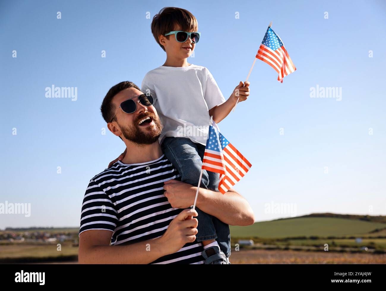 Happy father and son with flags of USA outdoors Stock Photo - Alamy