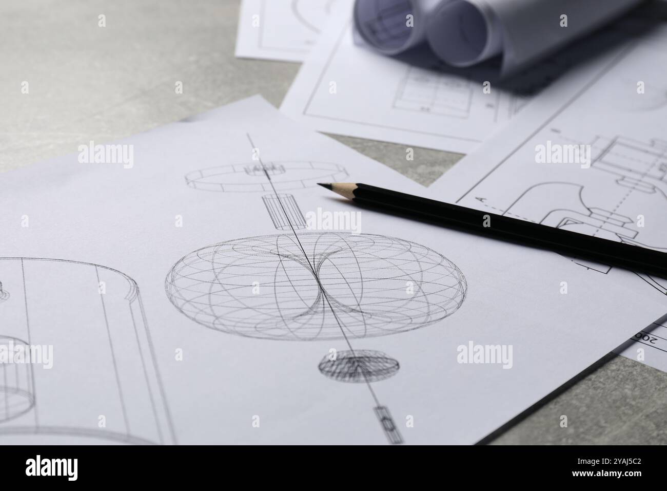 Different engineering drawings and pencil on gray textured table ...