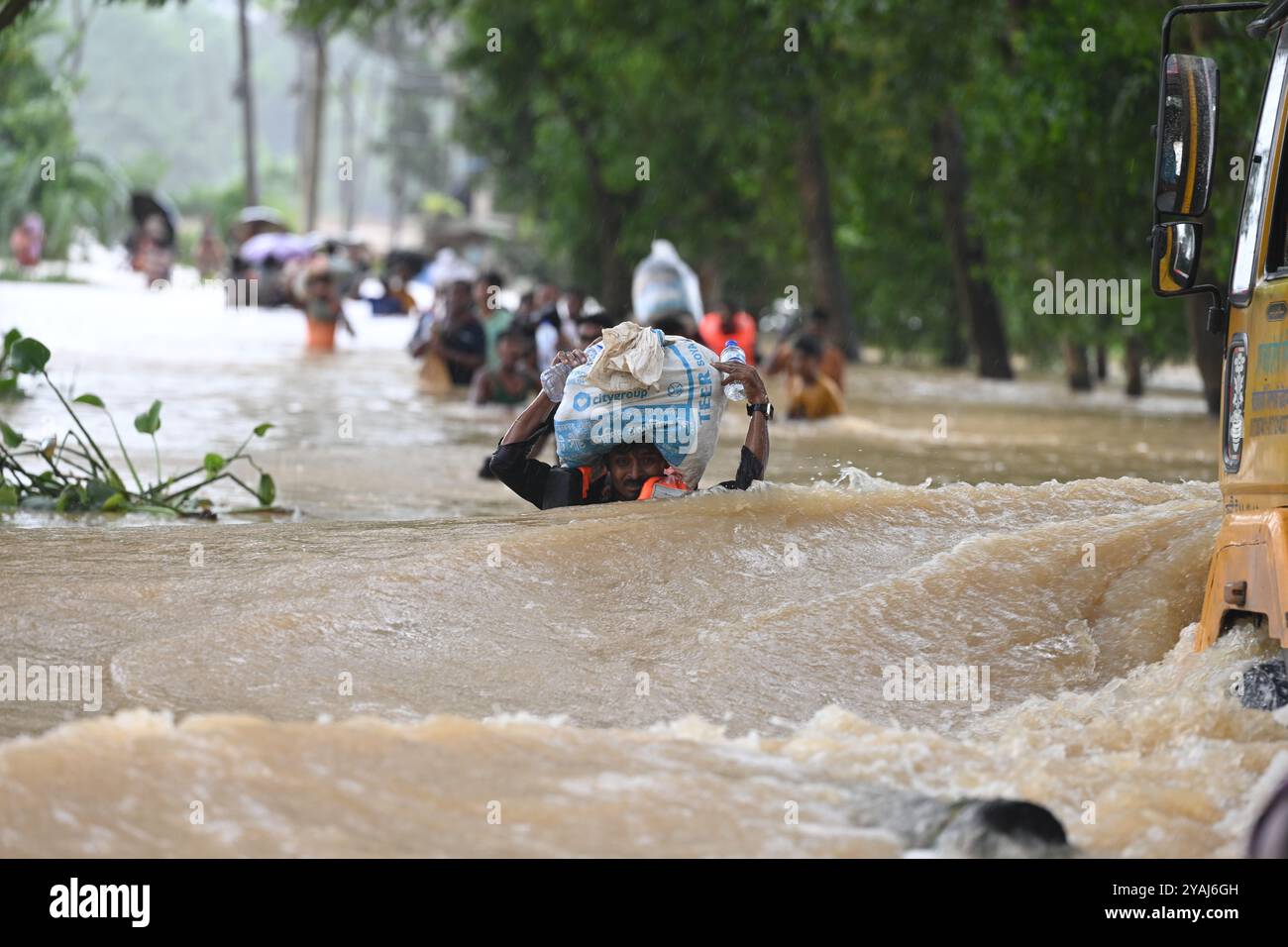 People wade through floodwaters in Feni District, Bangladesh, on August ...