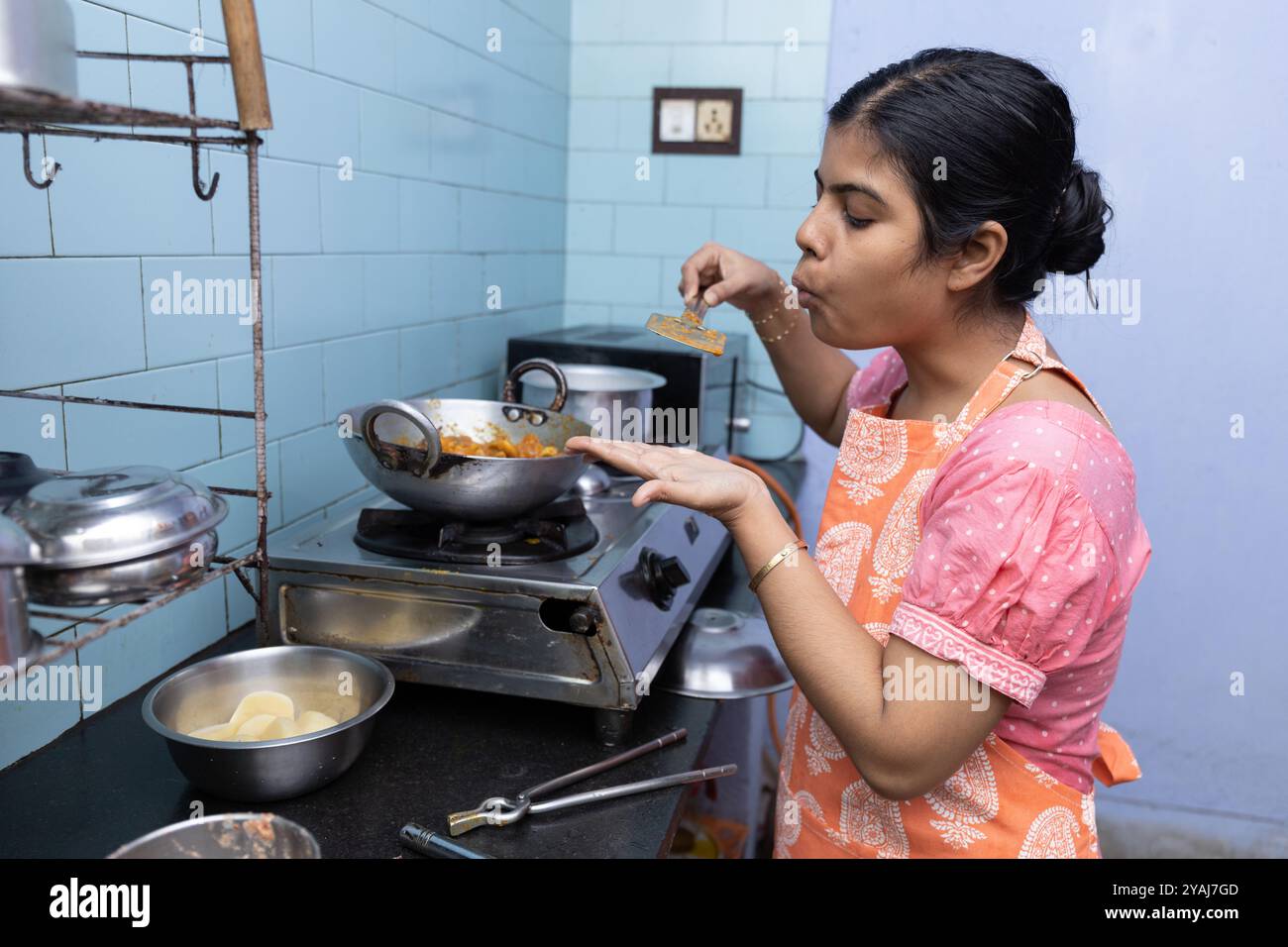 An Indian housewife of middle class family wearing cooking apron ...