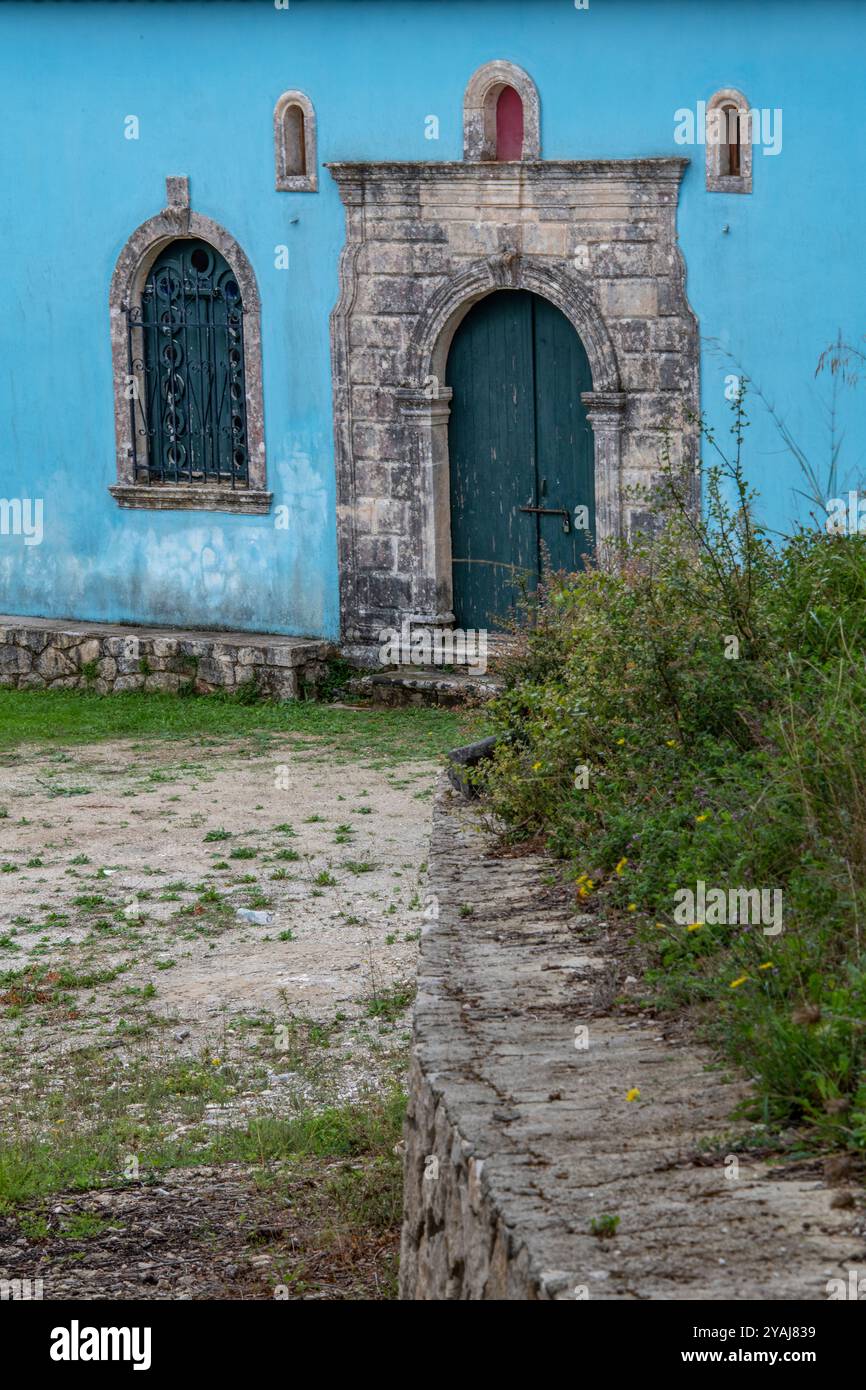 overgrown pathway leading to a disused Greek orthodox church painted ...