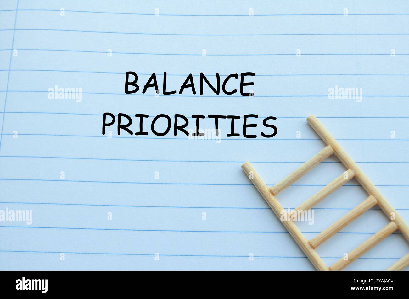 Balance priorities text on notebook with wooden ladder background ...
