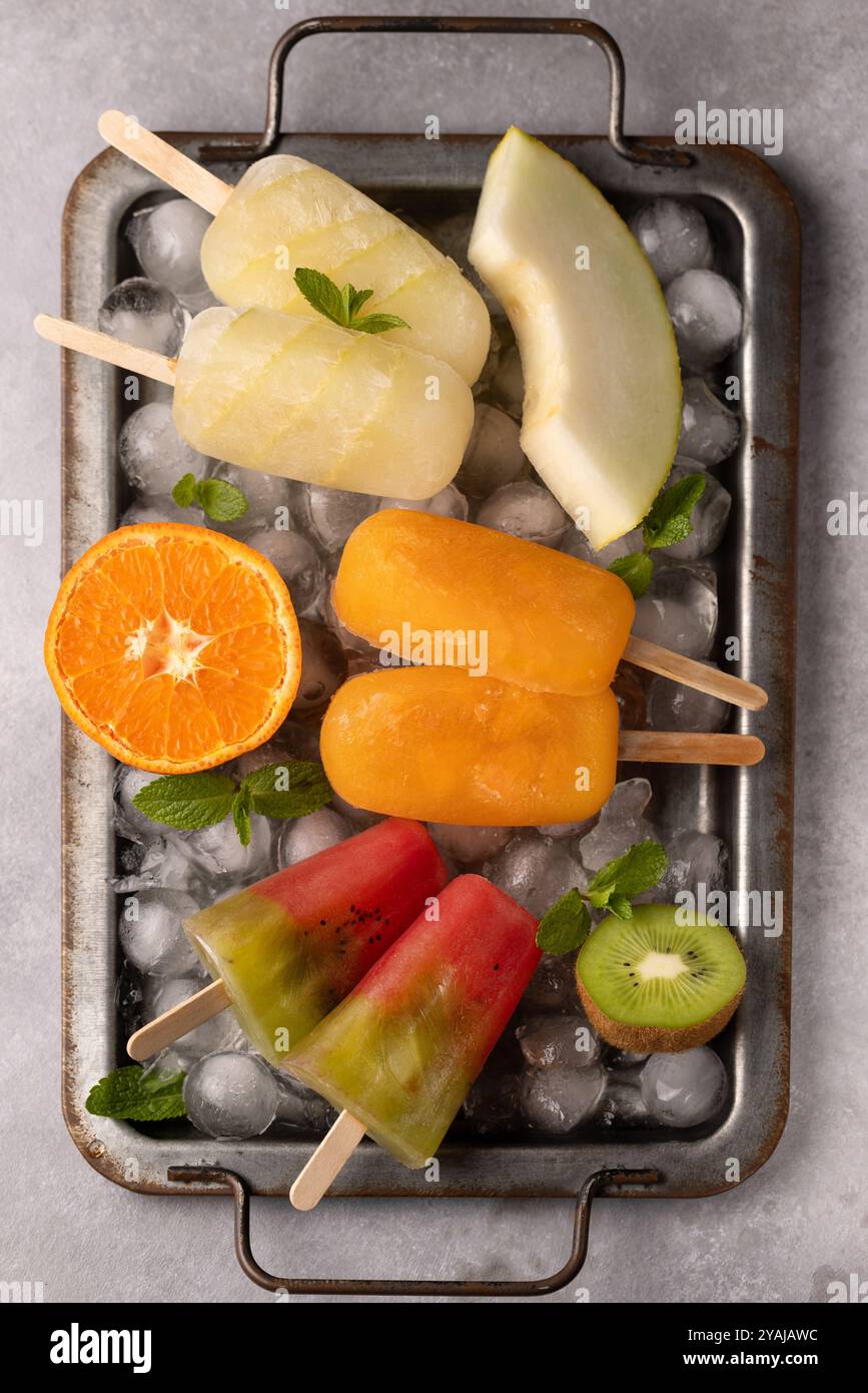 Assorted fruit ice on a stick of watermelon, kiwi, melon and tangerine ...