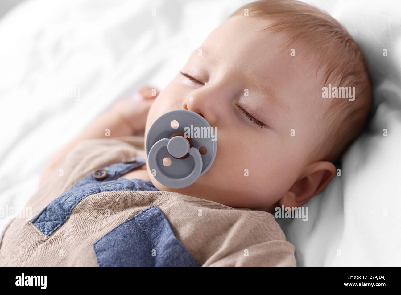 Cute little baby with pacifier sleeping on bed at home Stock Photo - Alamy
