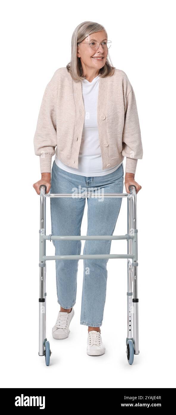 Senior woman using walking frame on white background Stock Photo - Alamy