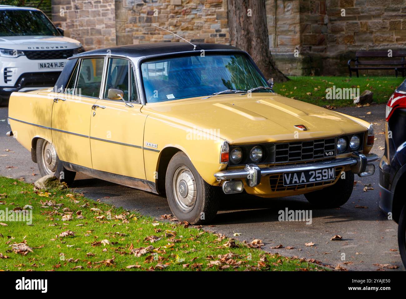Vintage yellow Rover P6 3500 car parked on a quiet street with fallen ...
