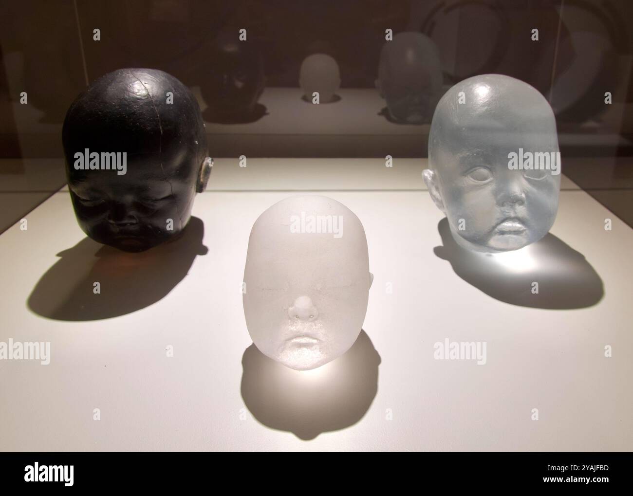 Translucent and black glass awake sleeping and new born baby head ...