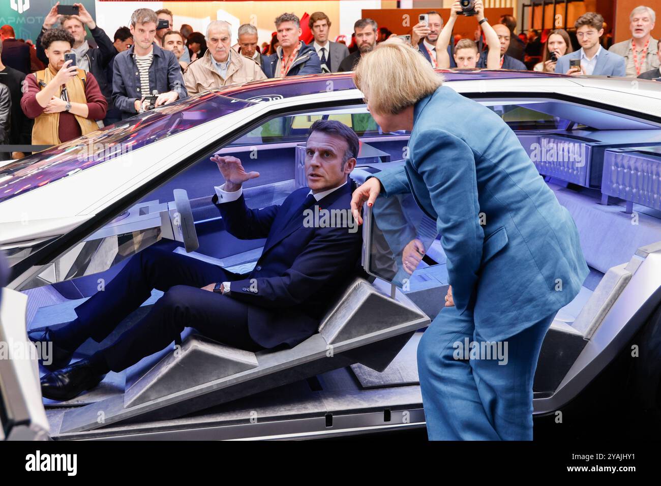 French President Emmanuel Macron sits aboard a Peugeot Inception ...
