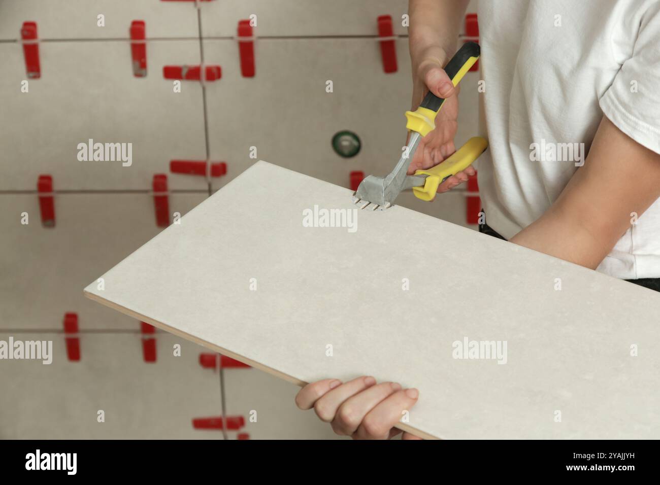 Worker cutting ceramic tile with ceramic tile cutter nipper. DIY home ...