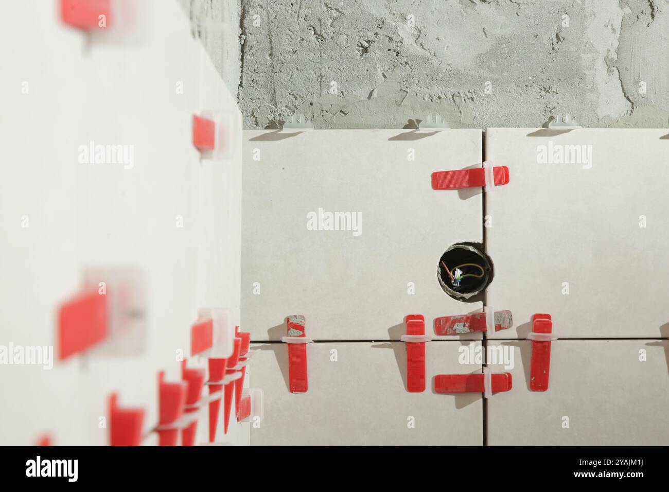 Flat wall plastic tile leveling system. Process of installation of ...