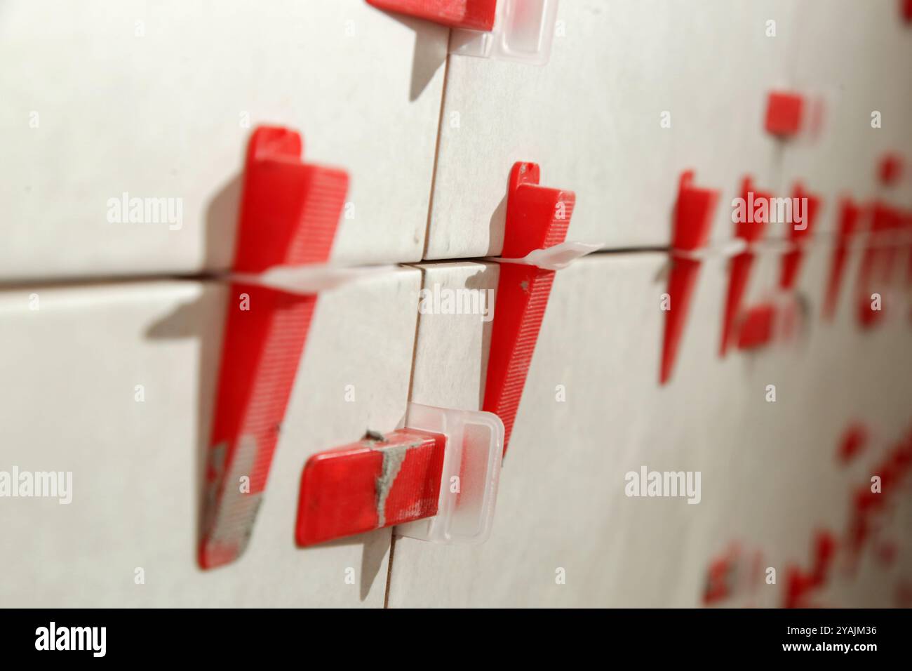 Flat wall plastic tile leveling system. Process of installation of ...