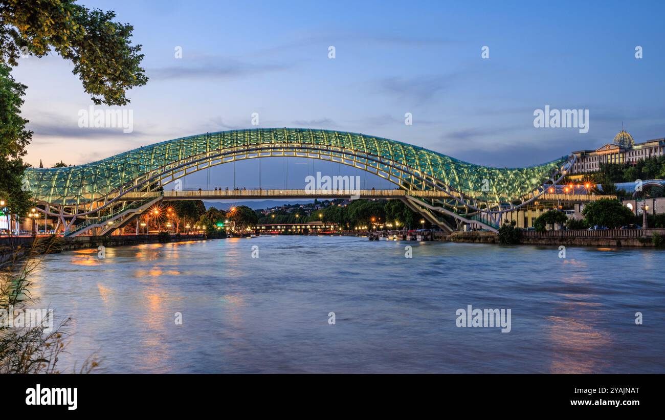 view along the river kura in tbilisi of the iconic peace bridge ...