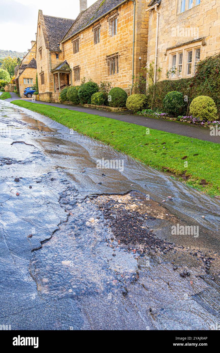Road surface breaking up due to heavy rain in the Cotswold village of ...
