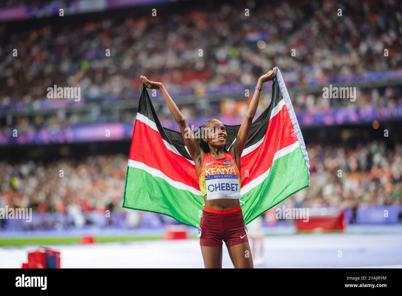Beatrice Chebet celebrating her victory with her country's flag in the ...