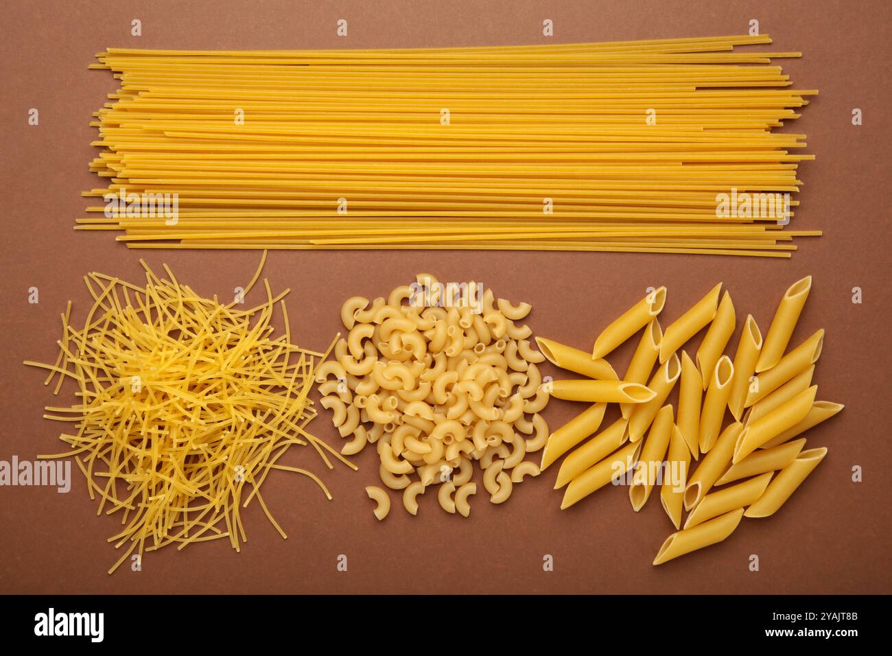 Assorted types of pasta on brown background. Various forms of pasta ...