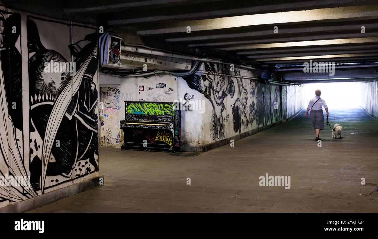 a woman walks her dog past the white walls of baratashvili underpass ...