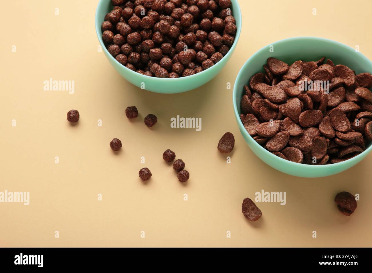 Different chocolate cereal corn in mint bowl on beige background. Copy ...