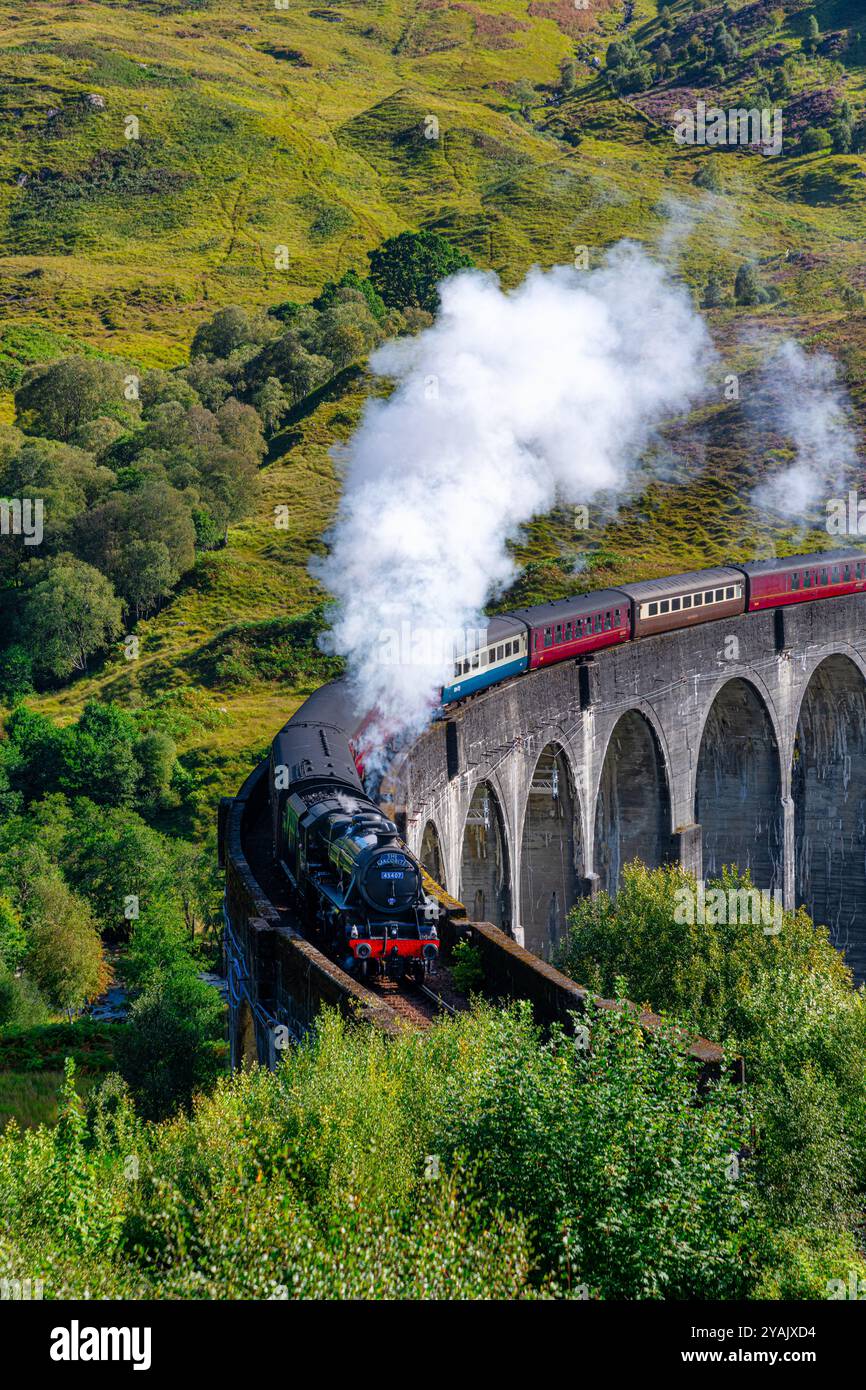 Steam train crossing the Glenfinnan Viaduct in Scotland, as featured in ...