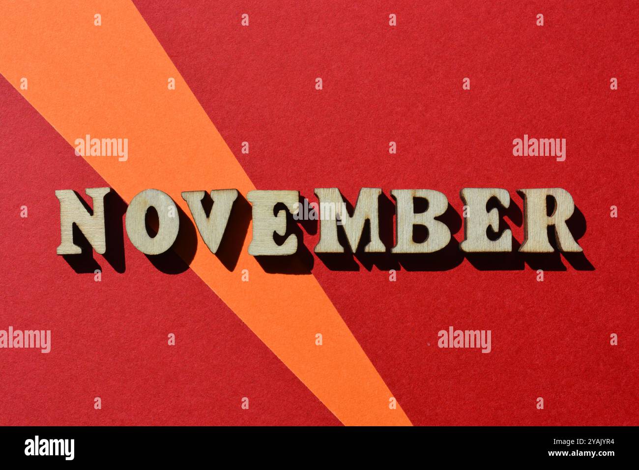 November, word in wooden alphabet letters isolated on red and orange ...