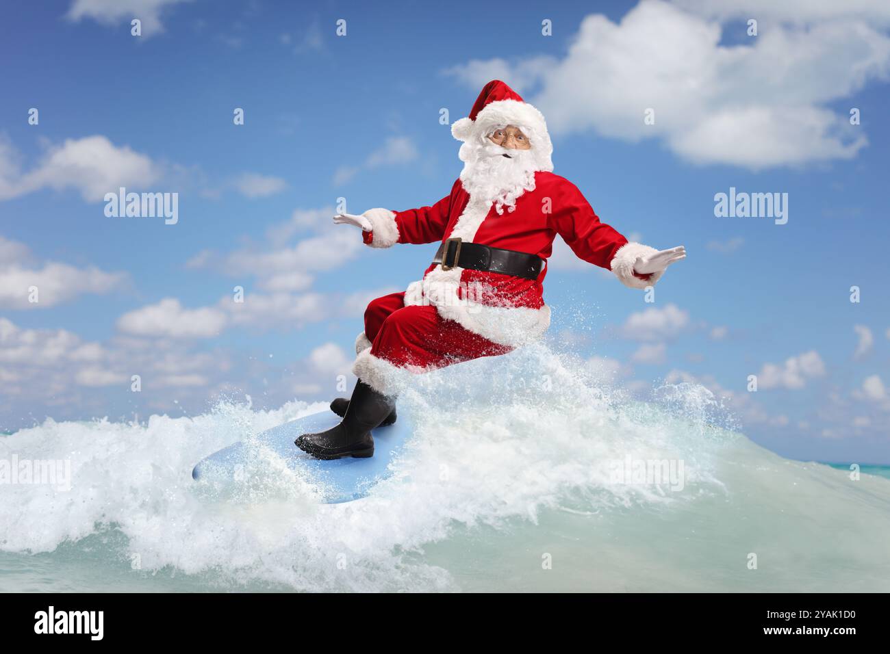 Santa claus riding a surfboard on a wave in the sea Stock Photo - Alamy
