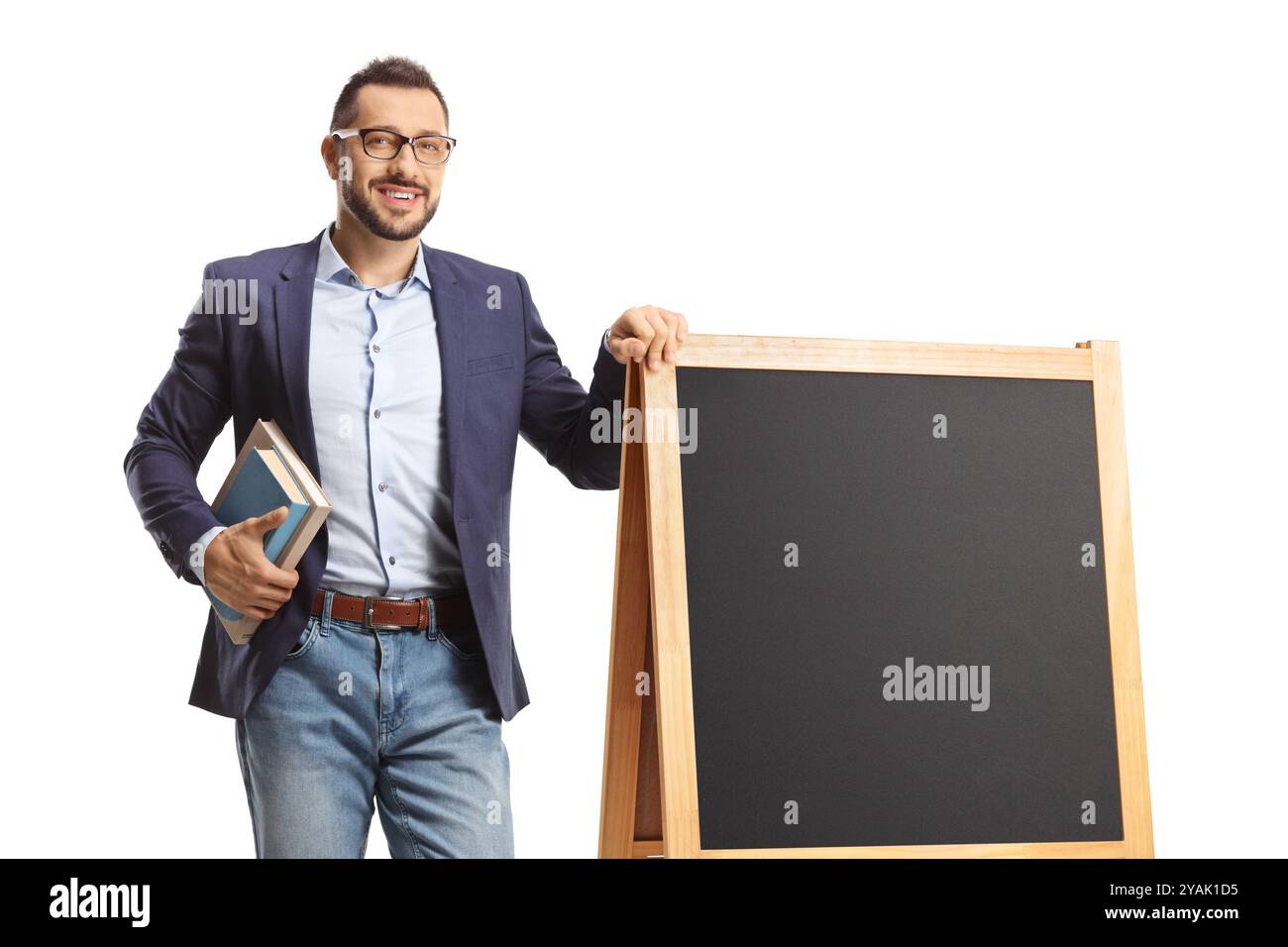 Young male teacher standing next to a blackboard isolated on white ...