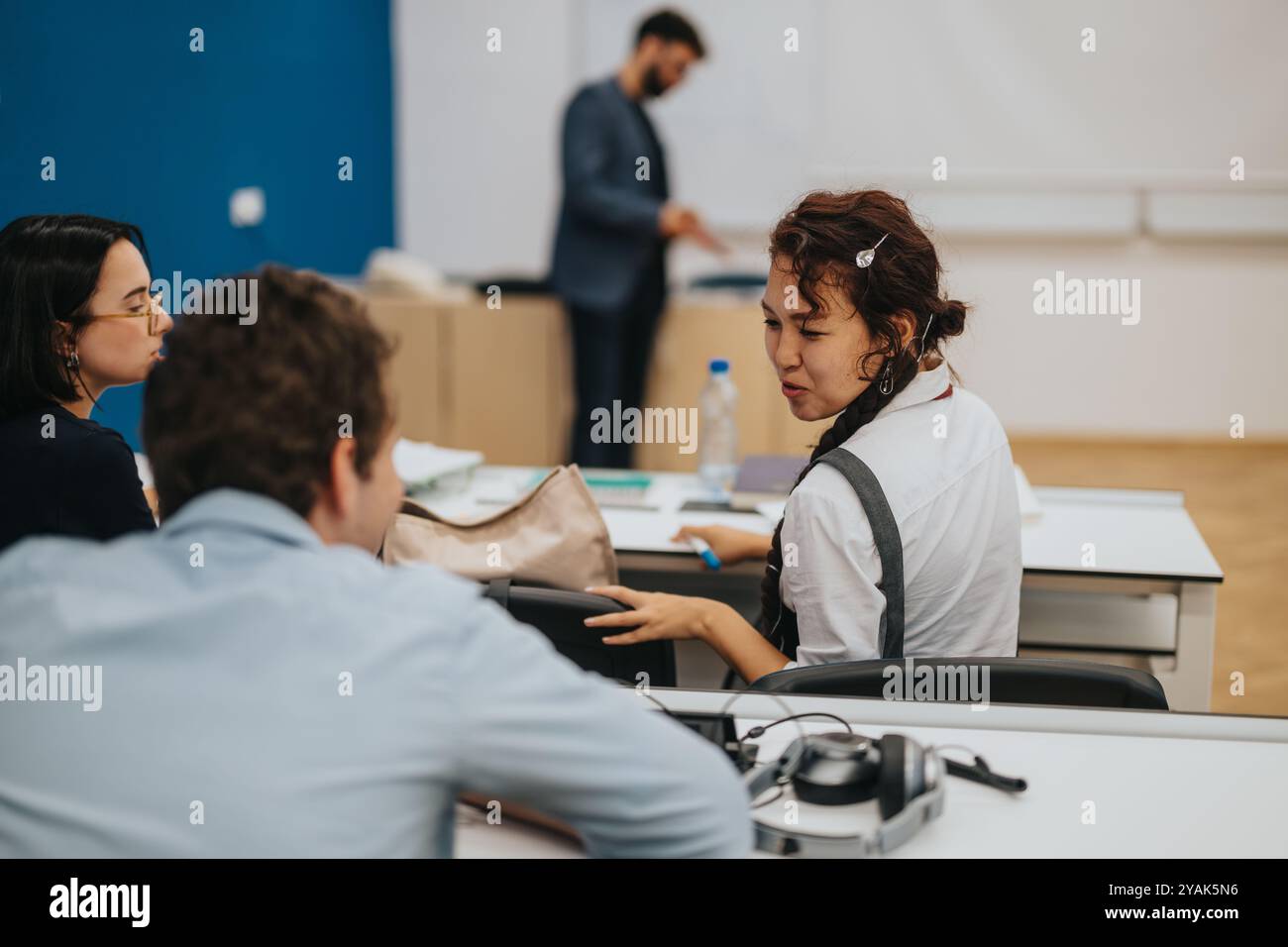 Students engaging in classroom tasks with attentive professor support ...