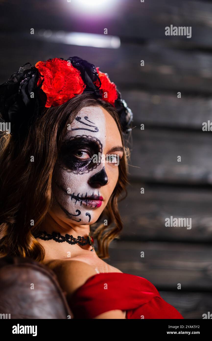 Young woman adorned with sugar skull makeup and a flower crown strikes ...