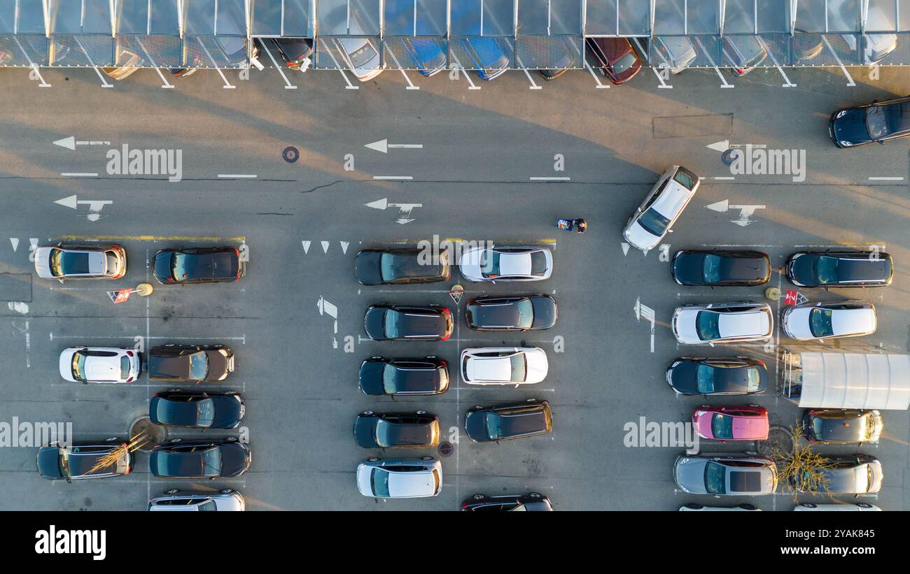 Aerial view of a parking lot with parked cars and a few empty spaces ...