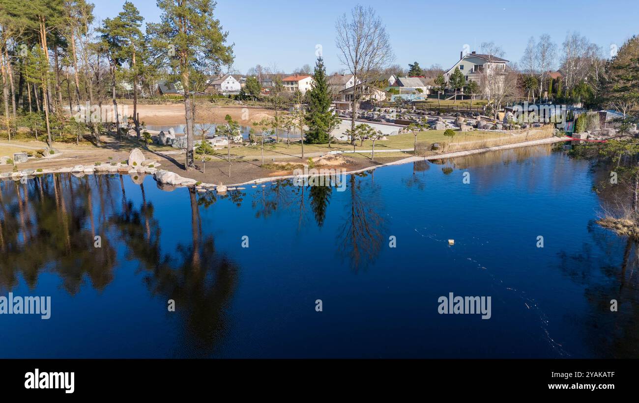 An aerial view of a construction site near a pond. The area shows a mix ...