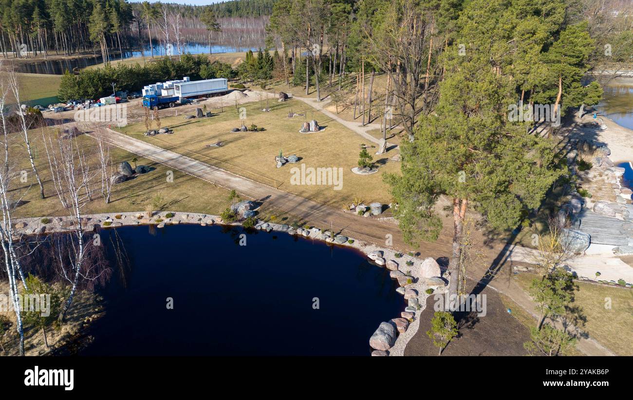 An aerial view of a construction site near a pond. The area shows a mix ...