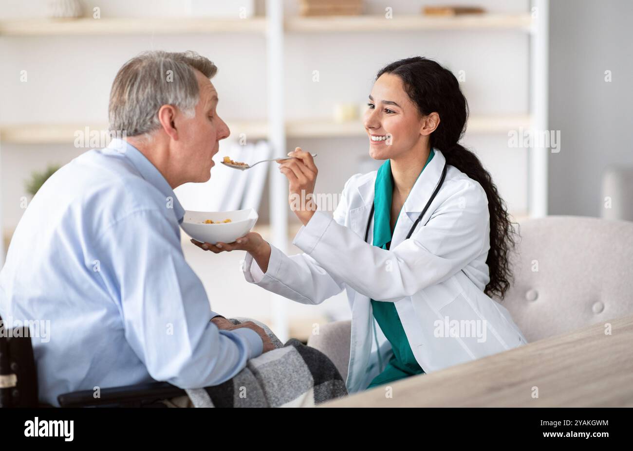 Medical assistance for elderly people with disabilities. Nurse feeding ...