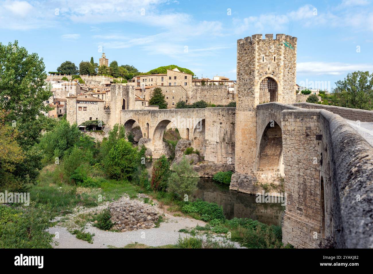 Bridge over a river giving access to a medieval city with a blue sky ...