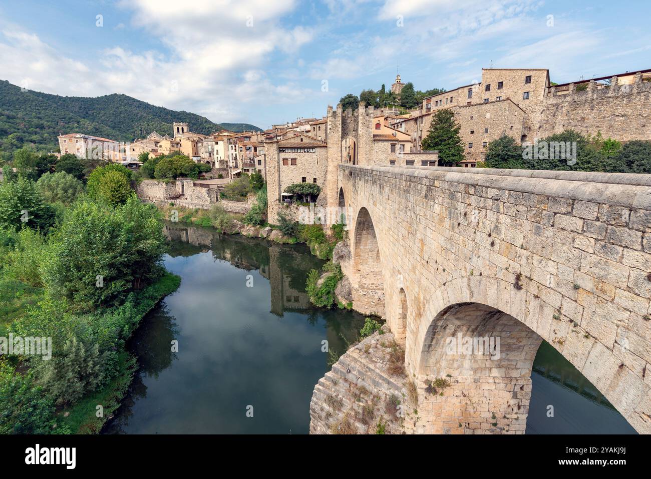 Bridge over a river giving access to a medieval city with a blue sky ...