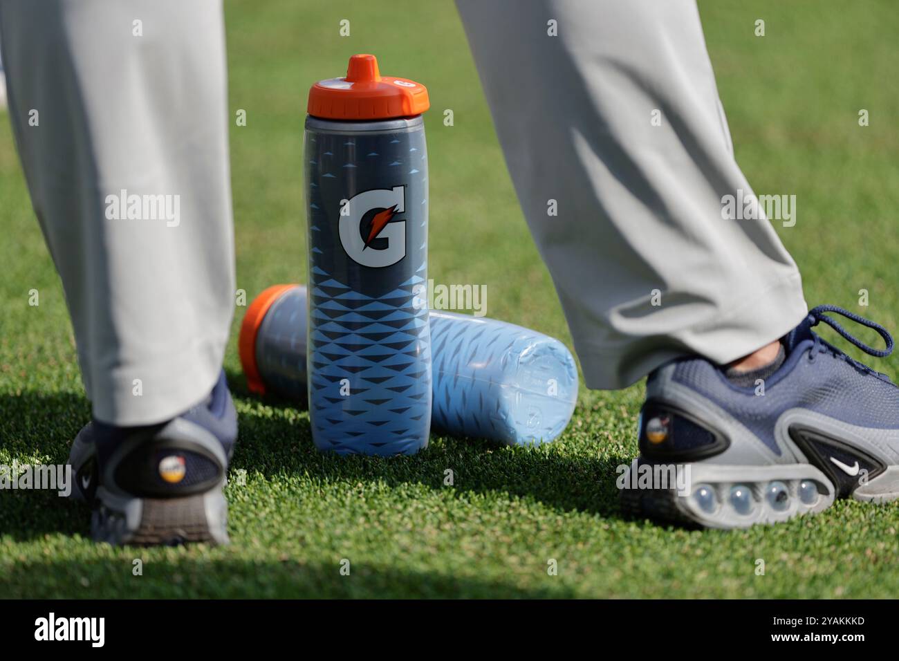 Gatorade bottles sit on the ground at the feet of a trainer prior to an ...