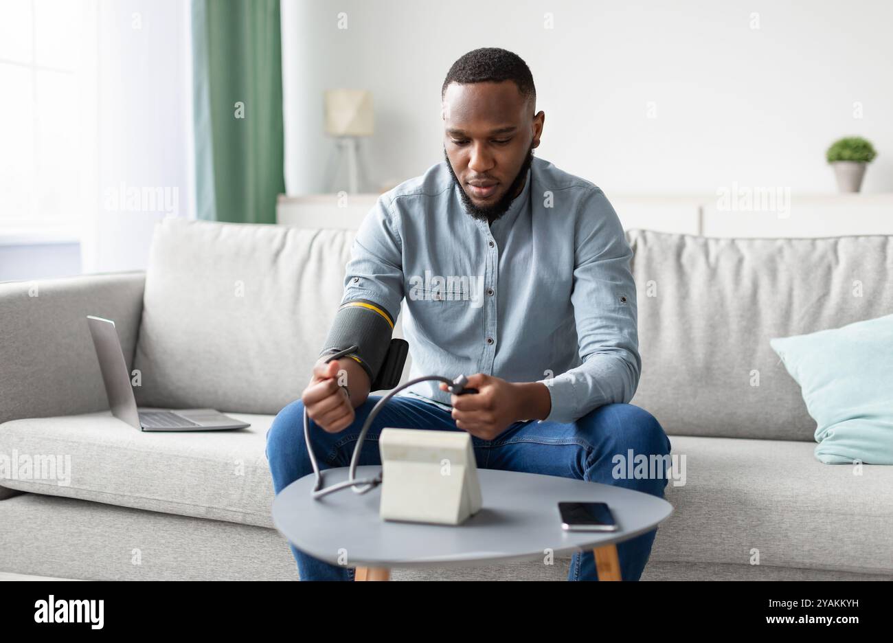 African Man Measuring Arterial Blood Pressure Sitting At Home Stock ...