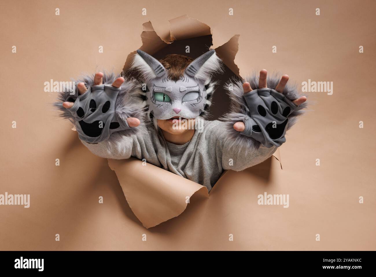 quadrobics portrait, Teenager in cat mask on beige background, studio ...