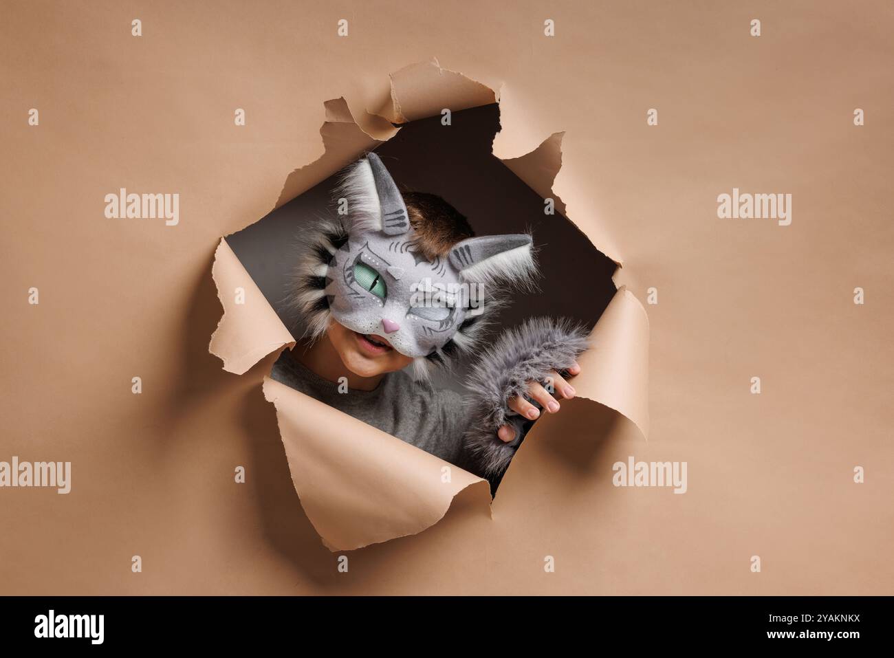 quadrobics portrait, Teenager in cat mask on beige background, studio ...