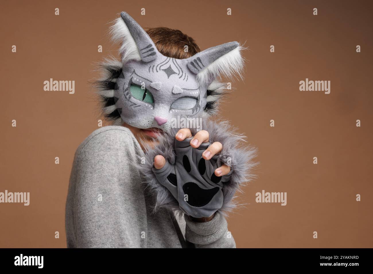 quadrobics portrait, Teenager in cat mask on beige background, studio ...