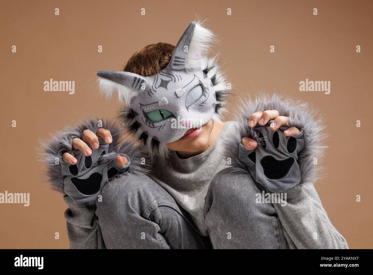 quadrobics portrait, Teenager in cat mask on beige background, studio ...
