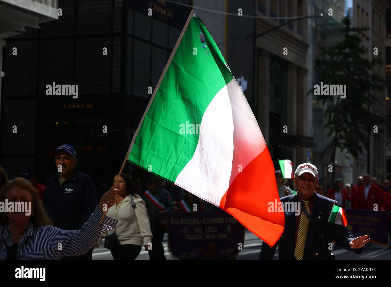 Participants wave flags as they march up 5th Avenue in the Columbus Day ...