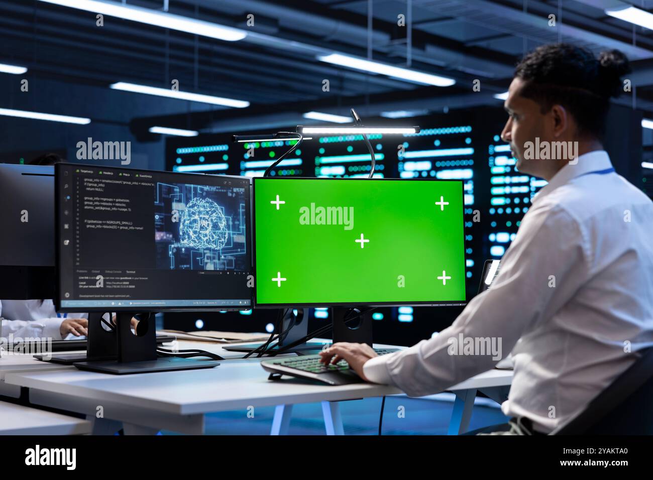 System administrator doing checkup on green screen computer in server hub used for artificial ...