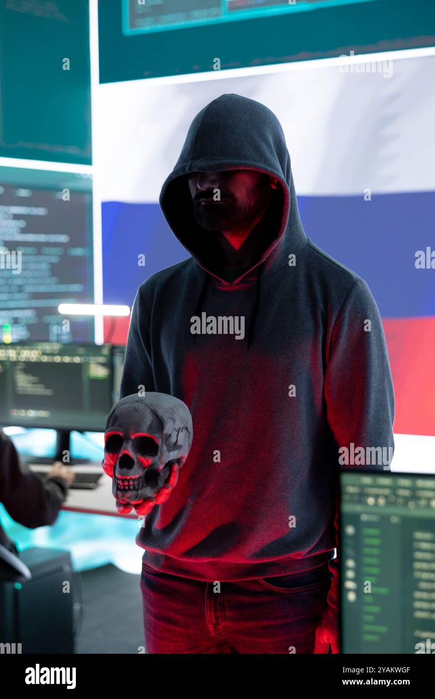 Digital outlaw hacker in a dark hood issuing cyber threats with a human ...
