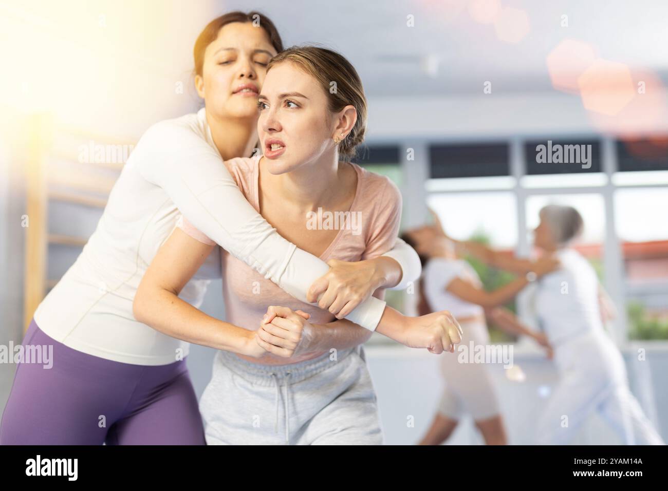 Woman and girl in gym perform basic elements of krav maga self-defense ...
